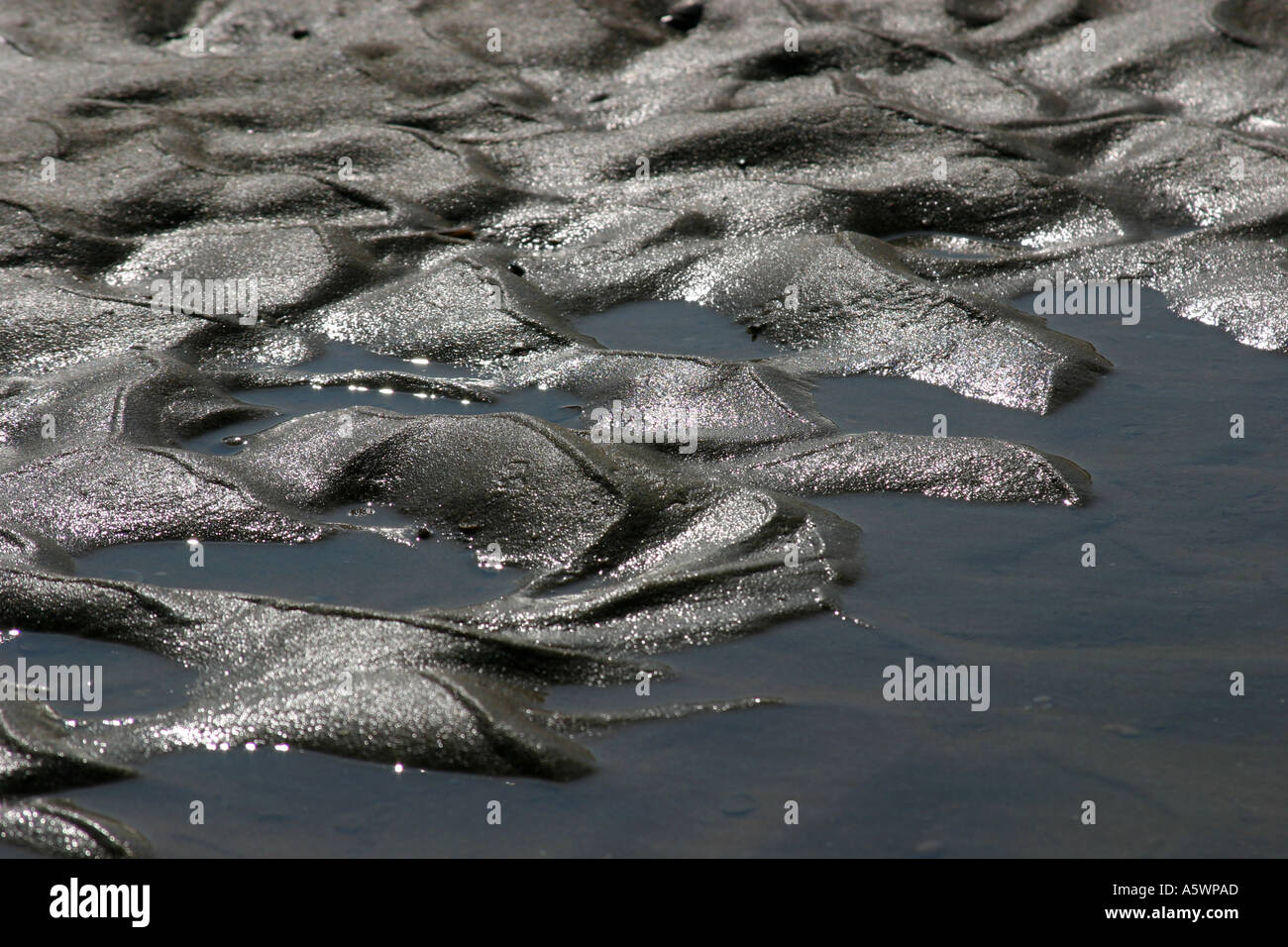 A wet patch of sand with patterns created by the waves Stock Photo - Alamy