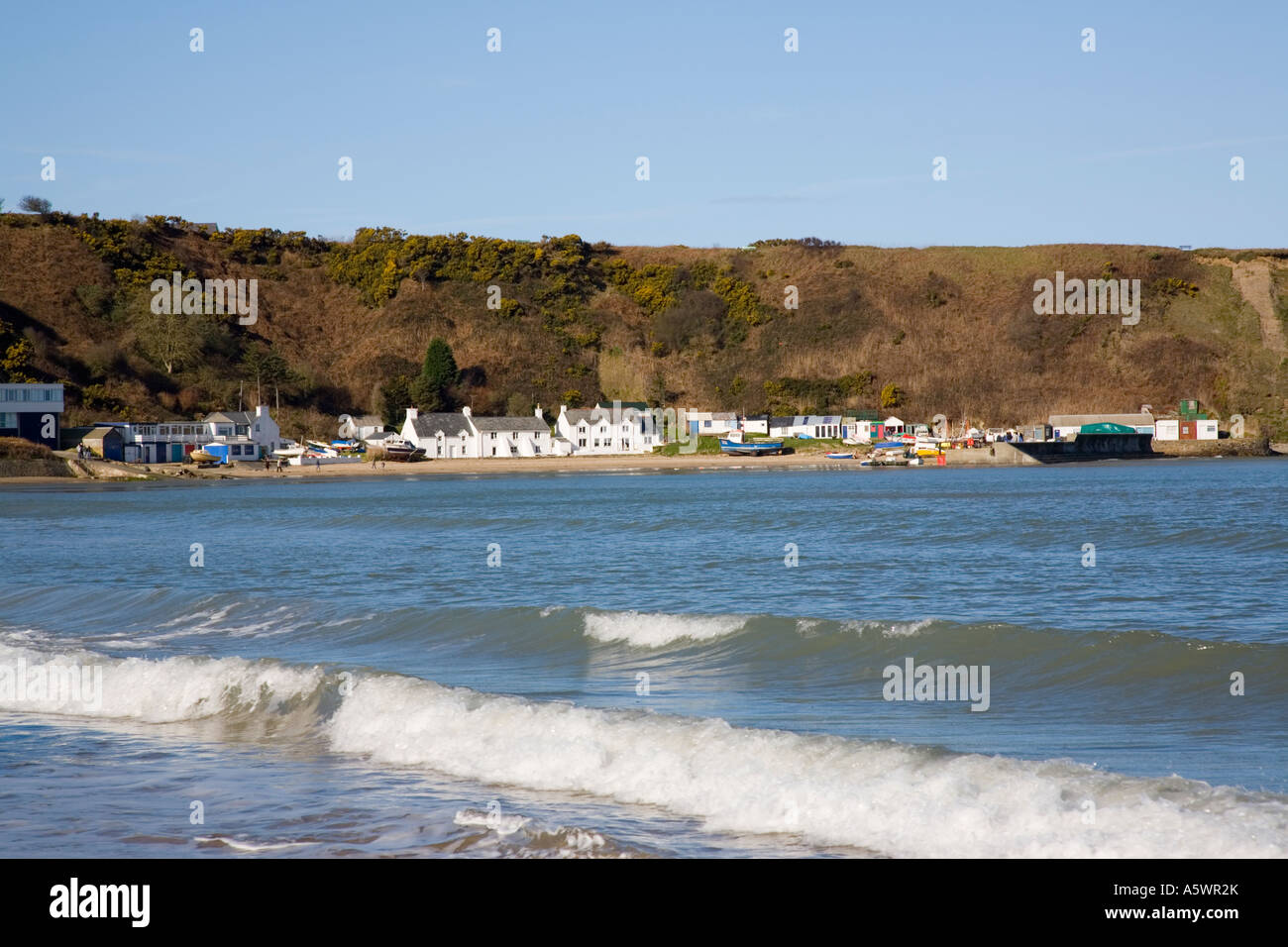 View across blue sea with white breaking waves to Penrhyn Nefyn in ...
