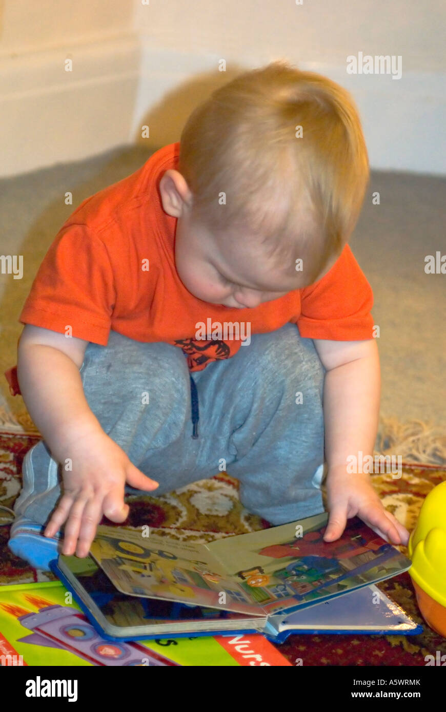 Baby boy looking at a book Stock Photo - Alamy
