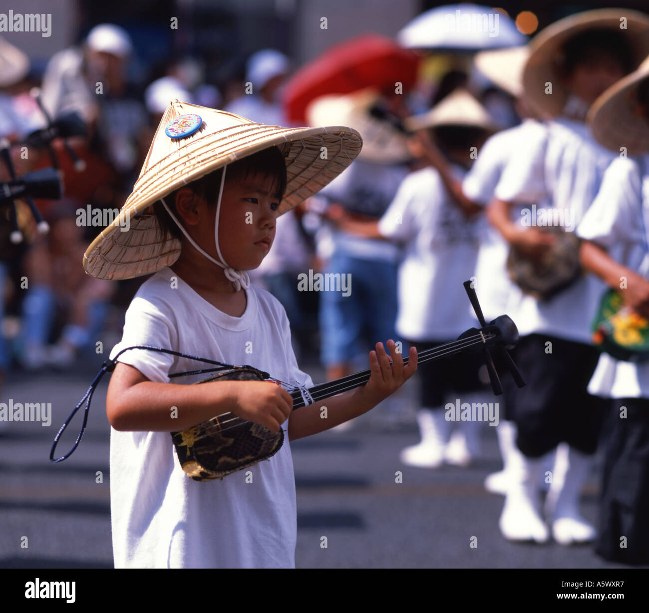 Young boy plays the sanshin the traditional three-stringed instrument ...