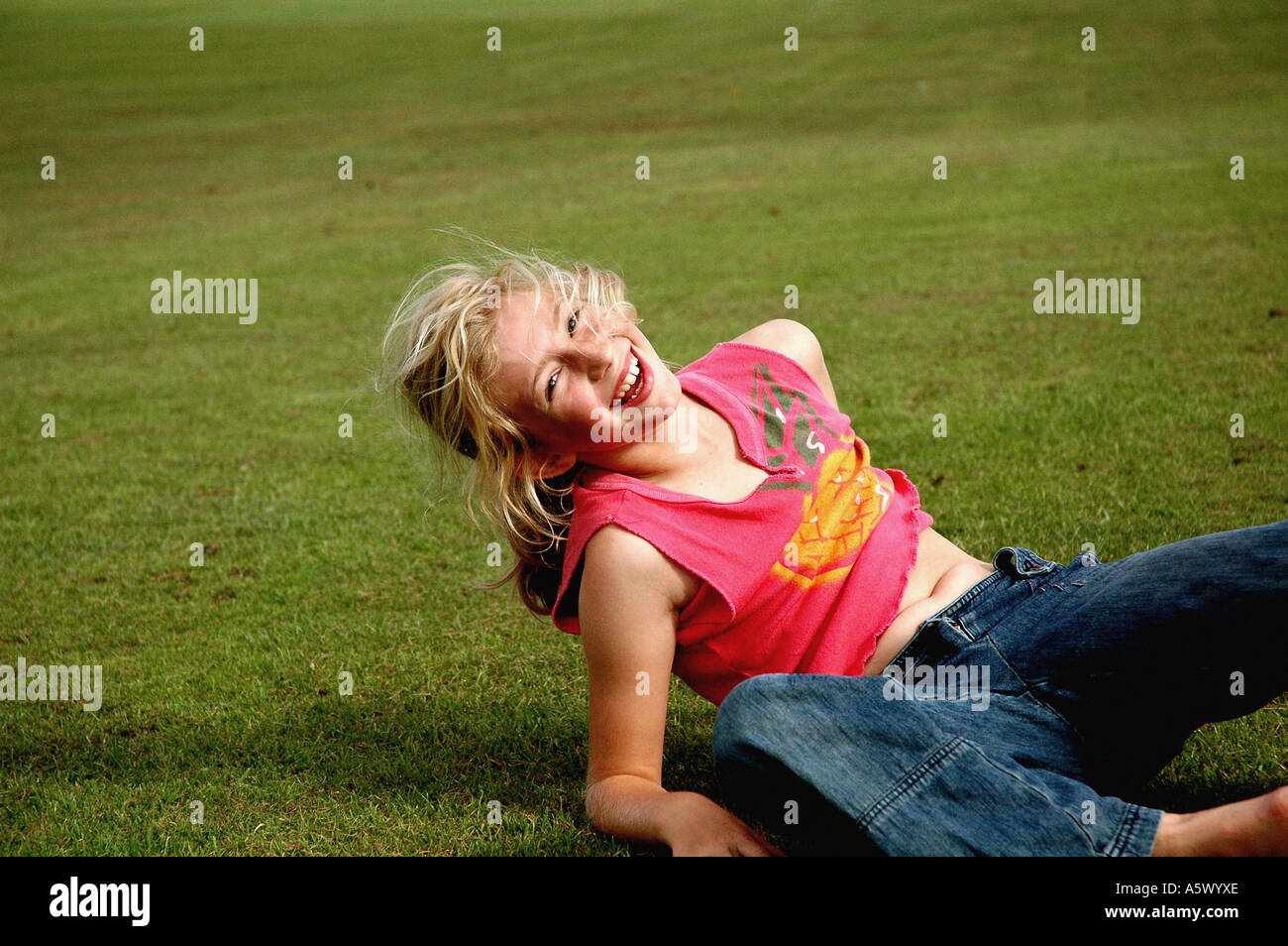young girl laughing and joking about on the grass at the park Stock ...