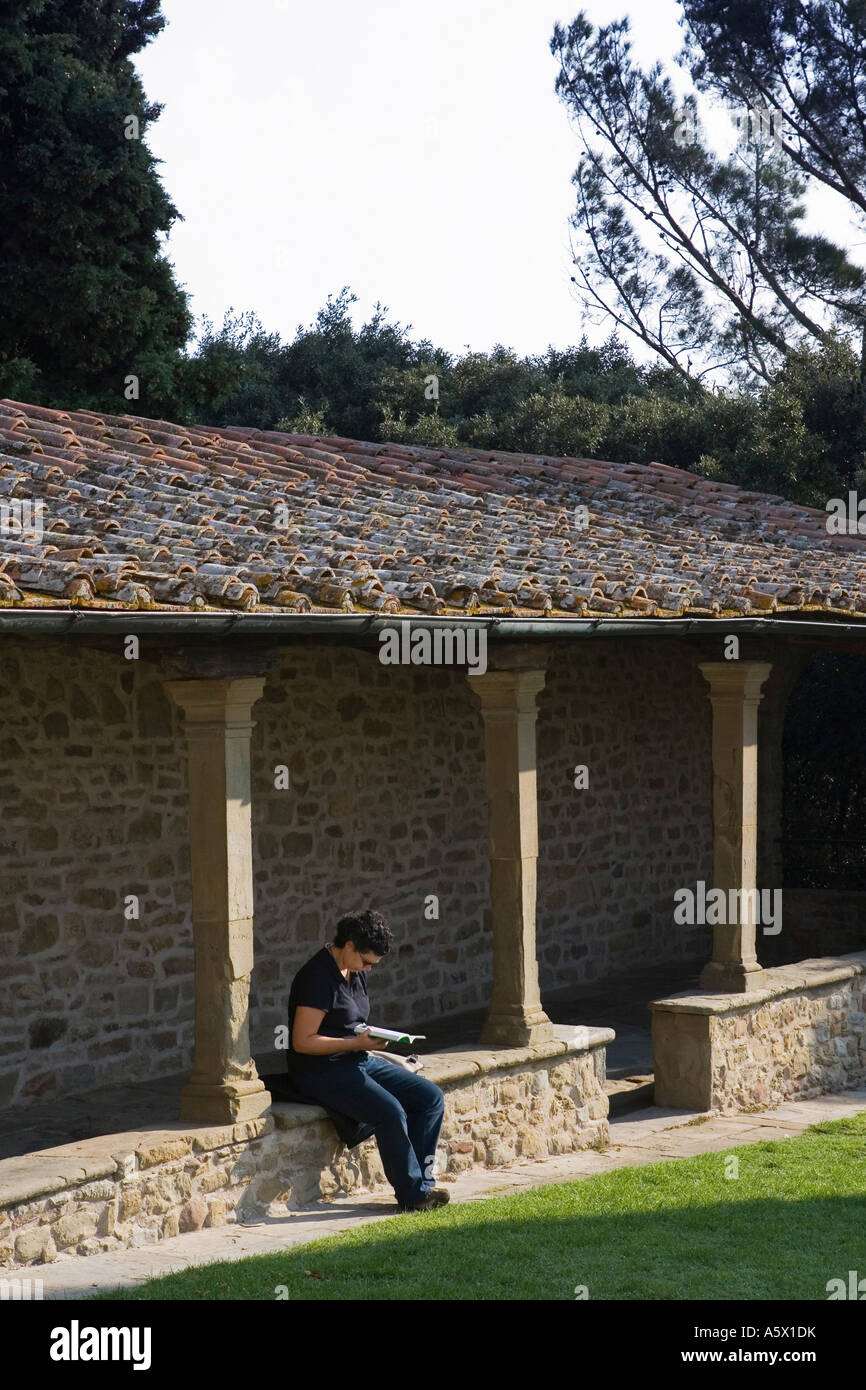 Woman sitting and reading in the garden of the monastery San Francesco ...