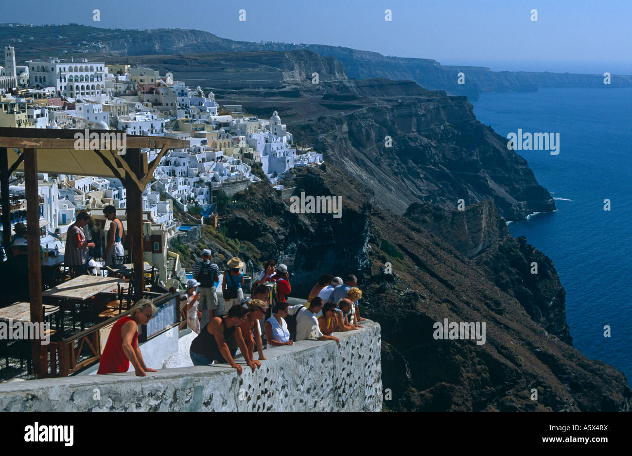 Tourists with View over the Caldera and town of Fira (Thira), Santorini ...