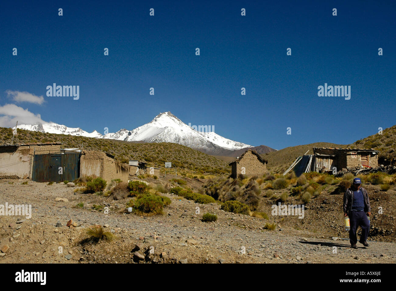 Man walking in poor village in border area with Volcano Pomerape, part ...