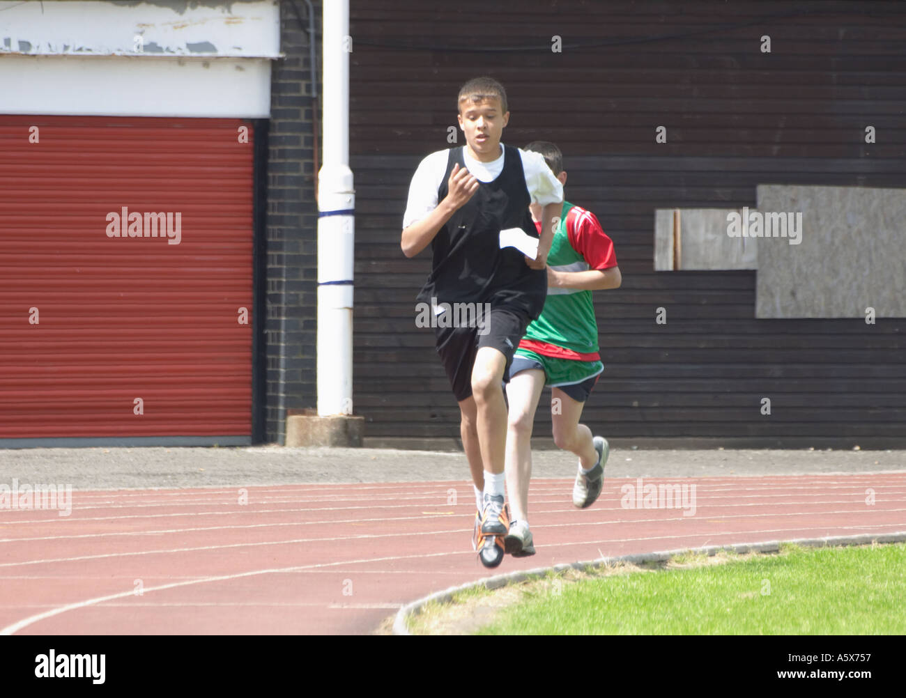 Young man on running track wearing black top and shorts athletics ...