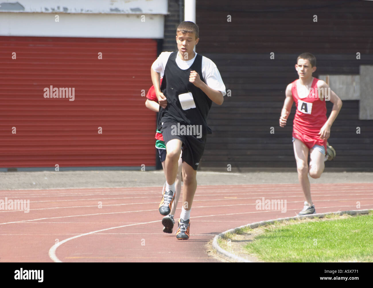Young man on running track wearing black top and shorts athletics ...