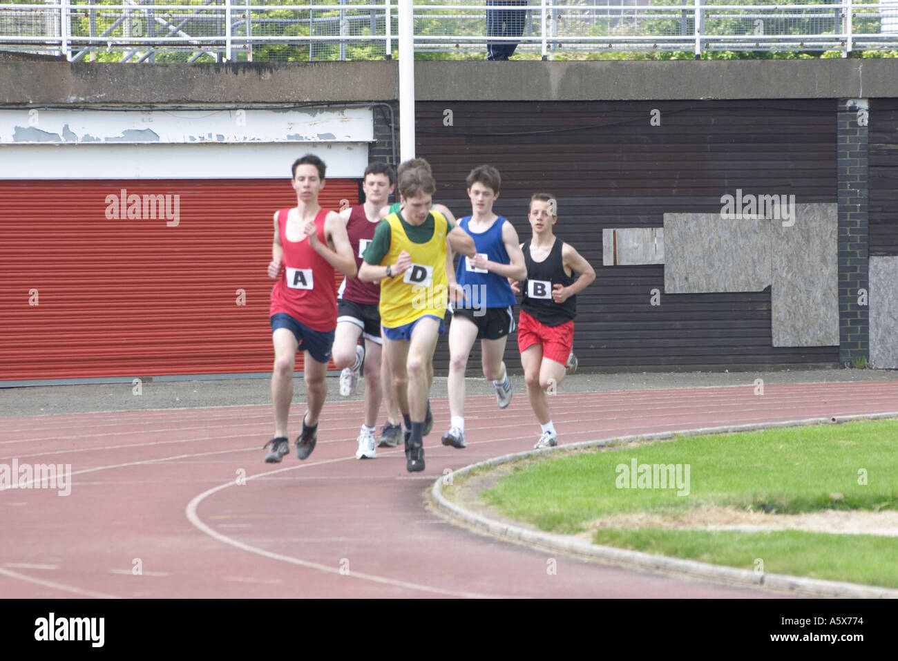 Young men on running track wearing different coloured tops athletics ...