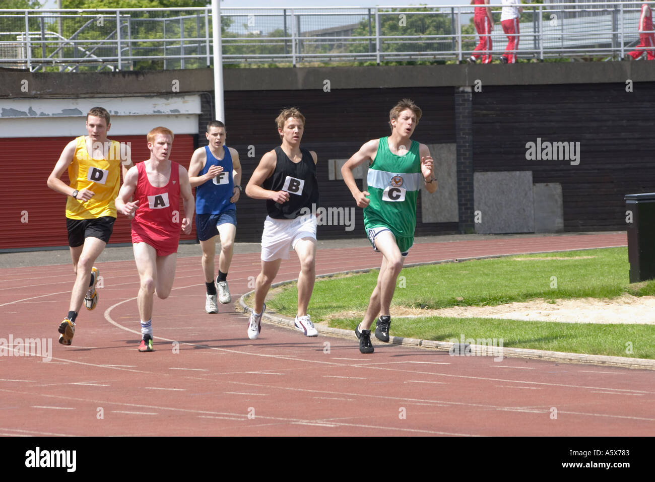Young men on running track wearing different coloured tops athletics ...