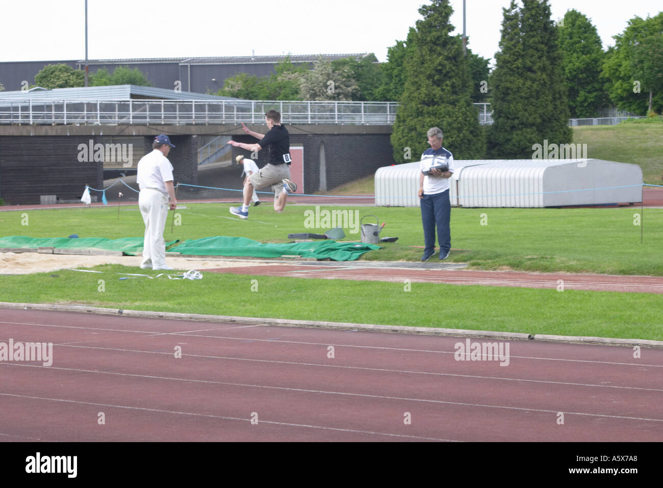 Young man jumping at Long jump athletics competition Stock Photo - Alamy