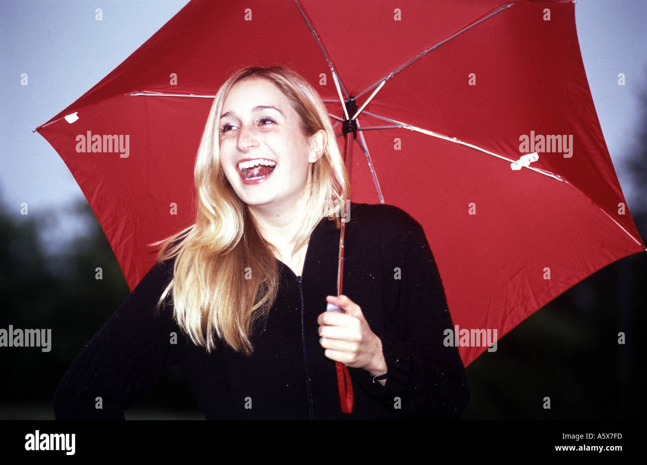 Young female model with red umbrella Stock Photo - Alamy