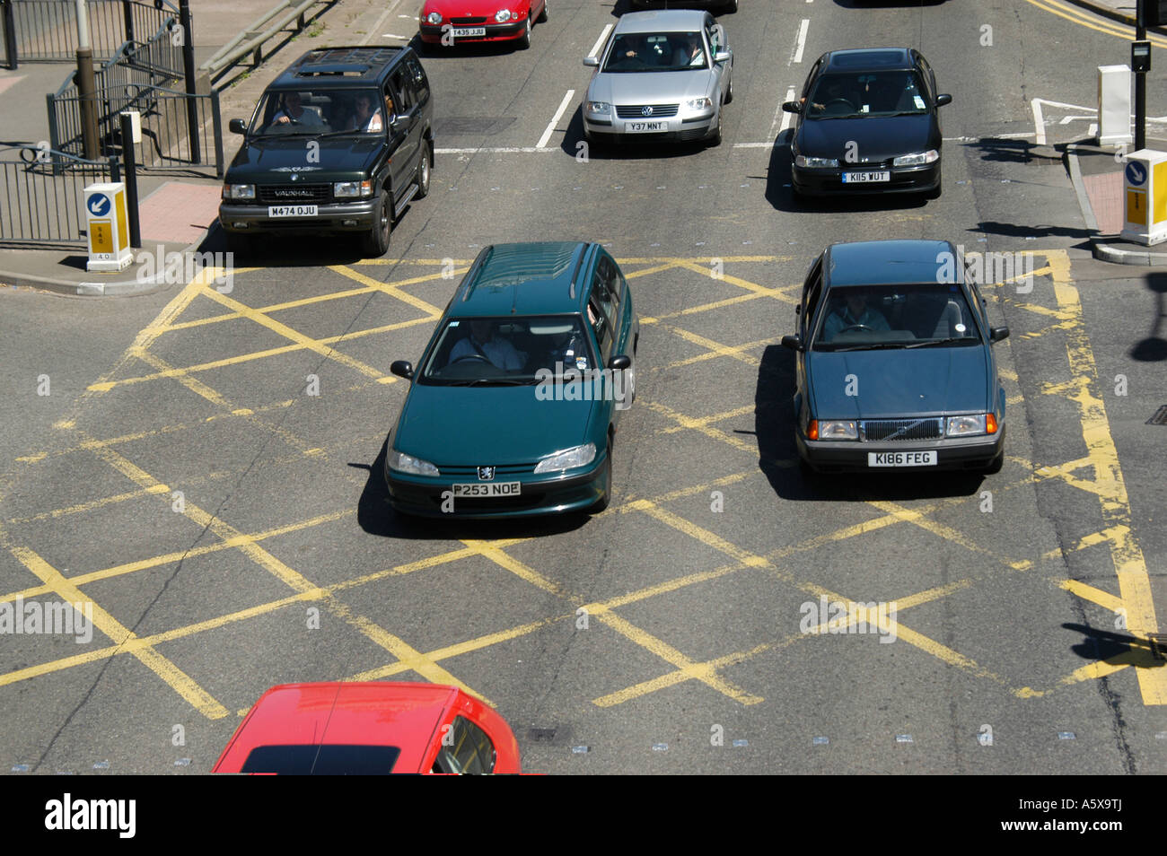Cars driving across a yellow box junction in a city centre in the uk ...