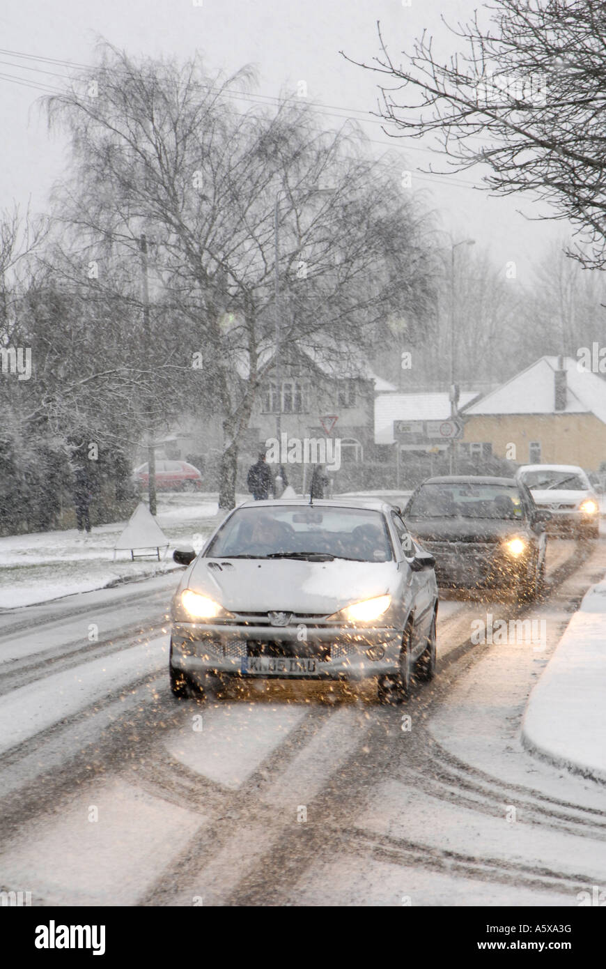 Traffic driving slowly to work on a snowy winters morning England Stock ...