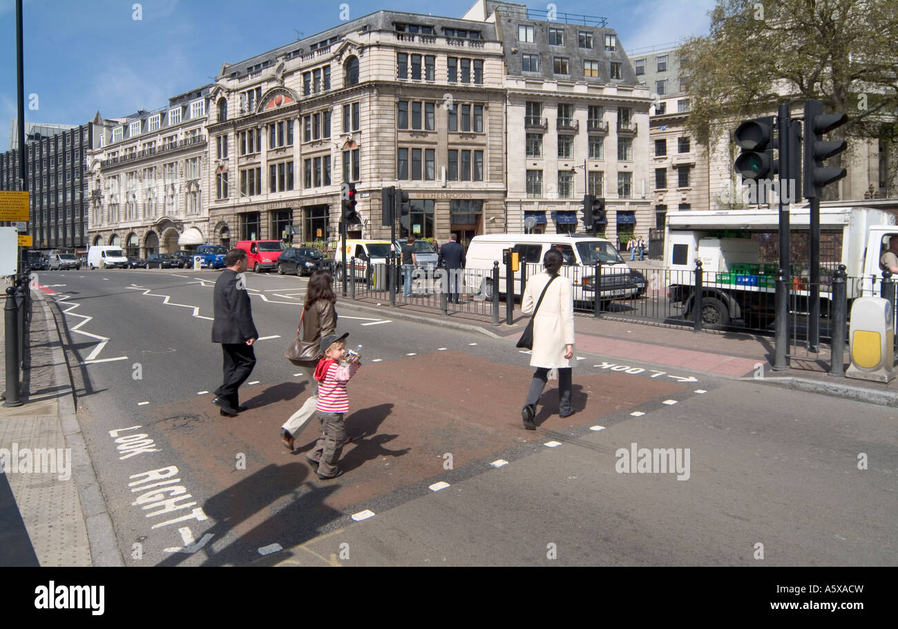 pedestrians crossing the road at a pedestrian crossing with the light ...