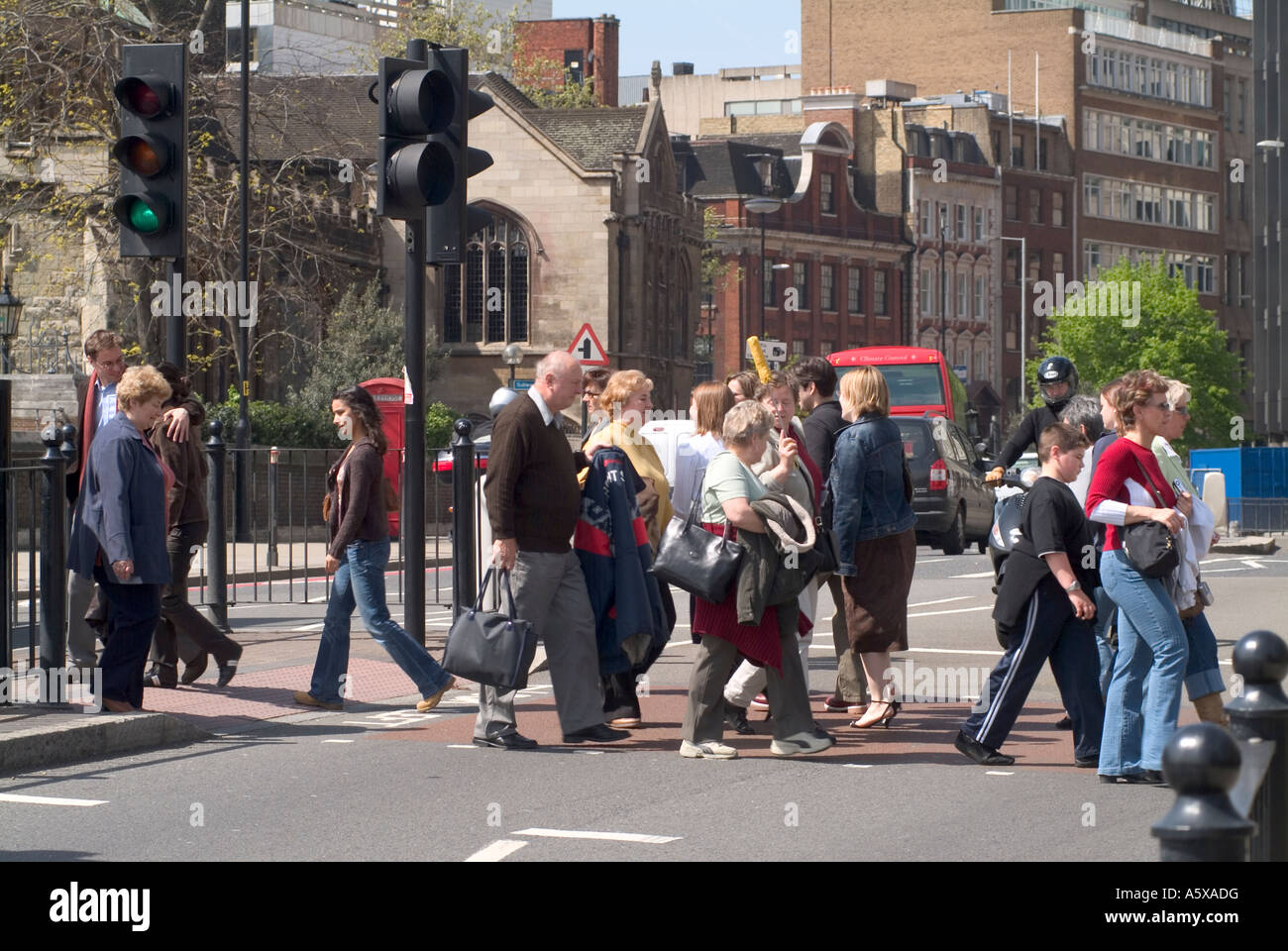 pedestrians crossing the road at a pedestrian crossing in london city ...
