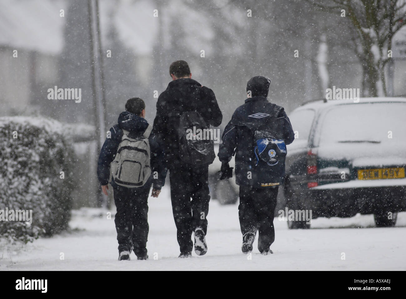 Children walking to school in the snow on a winters morning in england ...