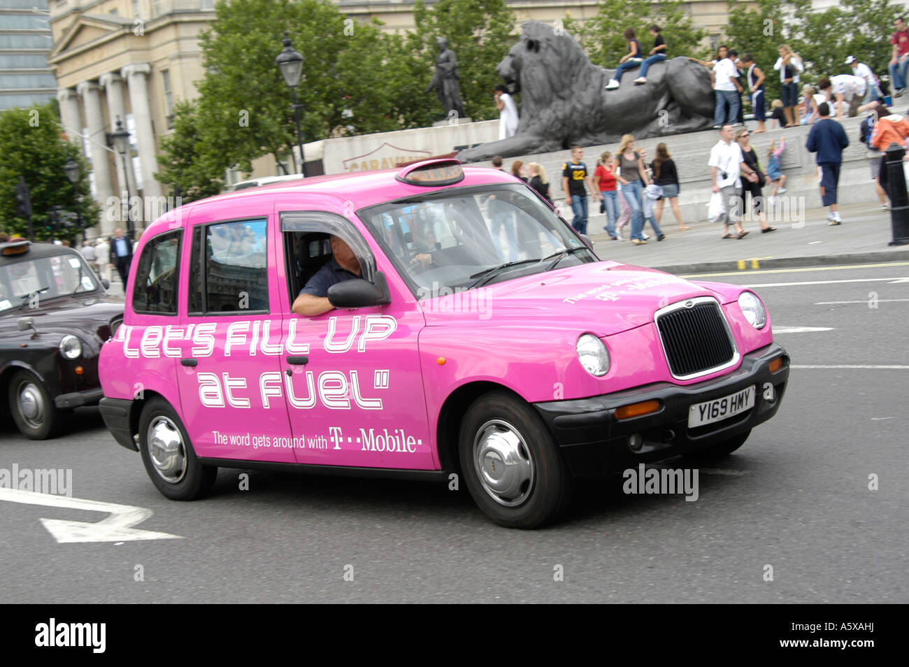Pink taxi cab travelling past Trafalgar Square in London Stock Photo ...