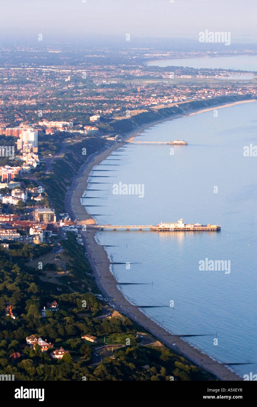 Aerial view. Evening sun shining on Bournemouth and Boscombe piers and ...