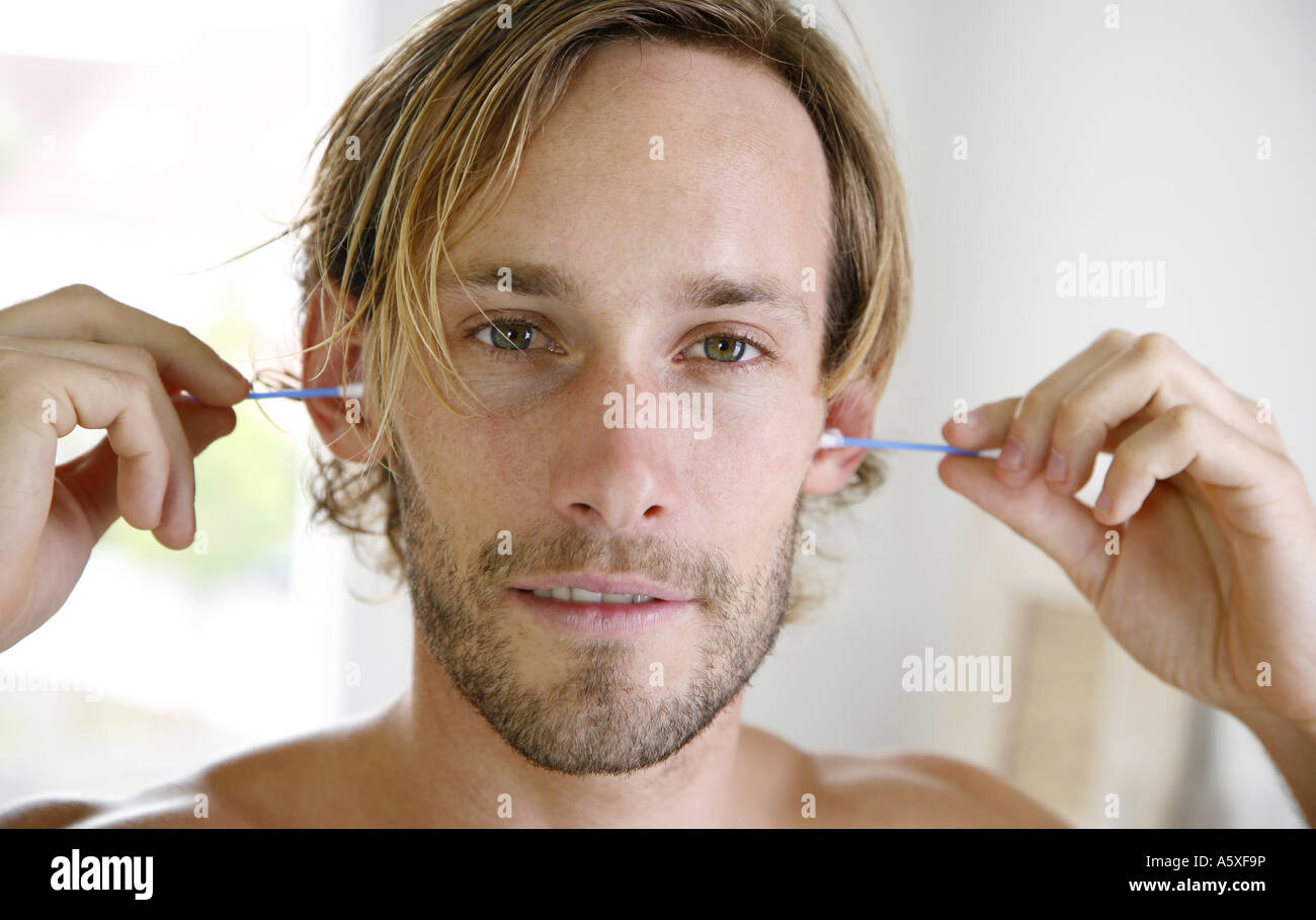 Young man cleaning ear close up portrait Stock Photo - Alamy