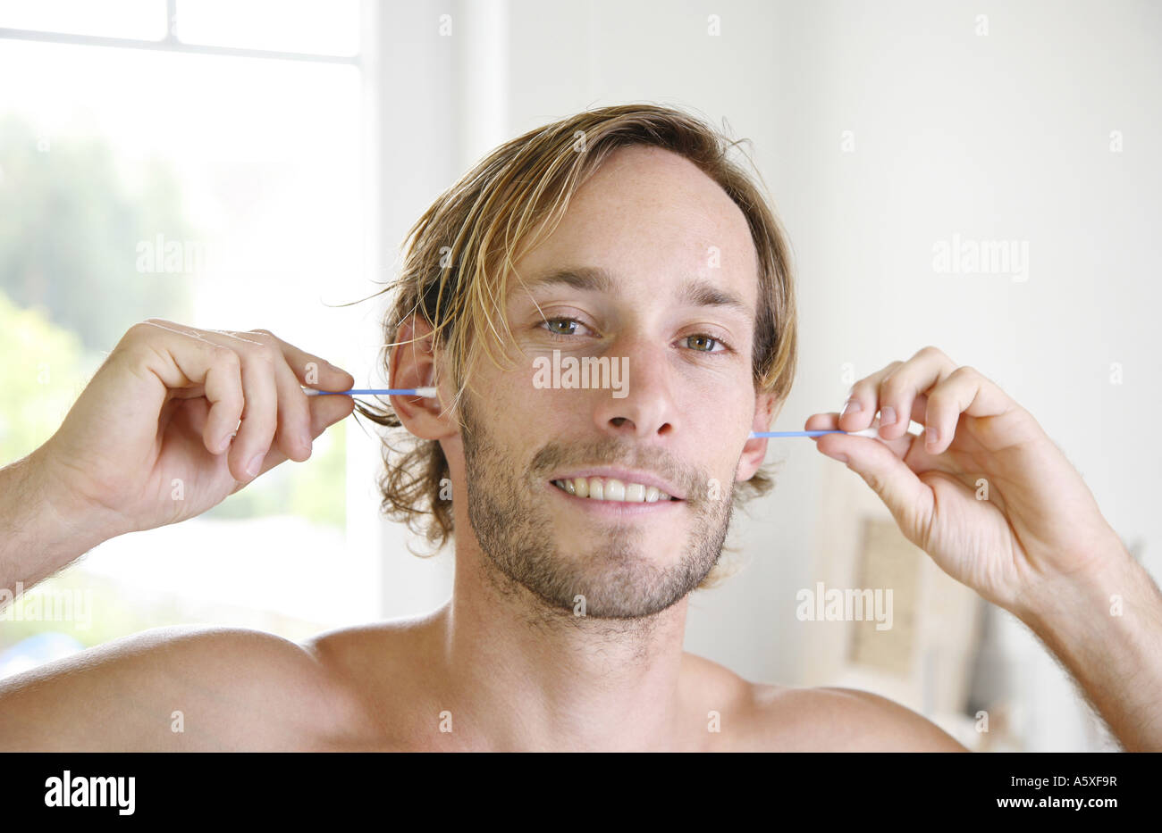 Young man cleaning ear close up portrait Stock Photo - Alamy
