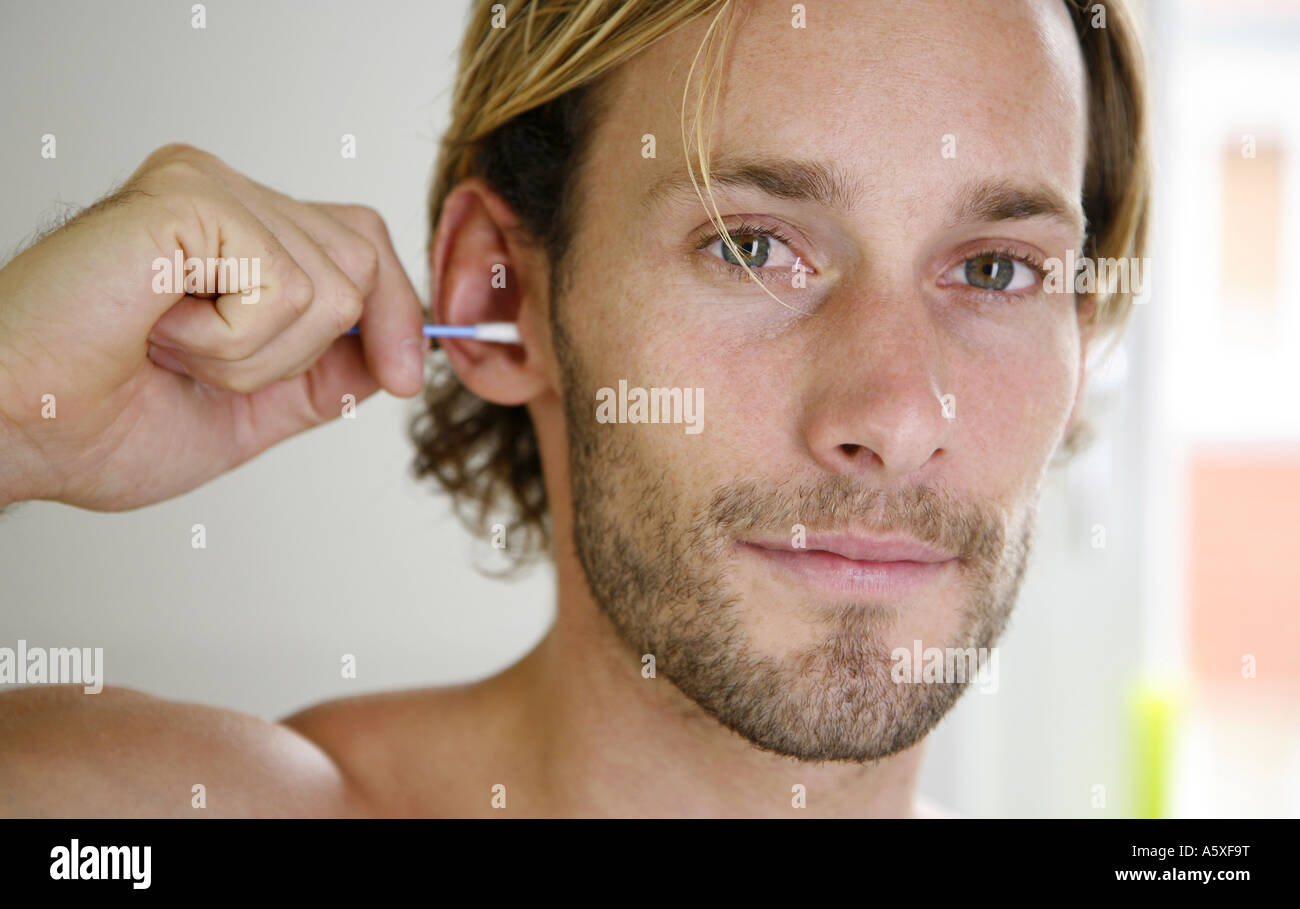 Young man cleaning ear close up portrait Stock Photo - Alamy