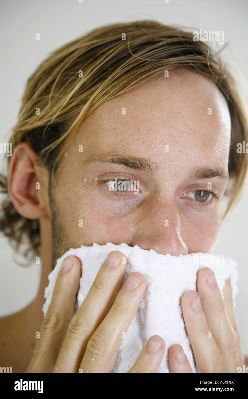 Young man drying his face with a towel close up portrait Stock Photo ...