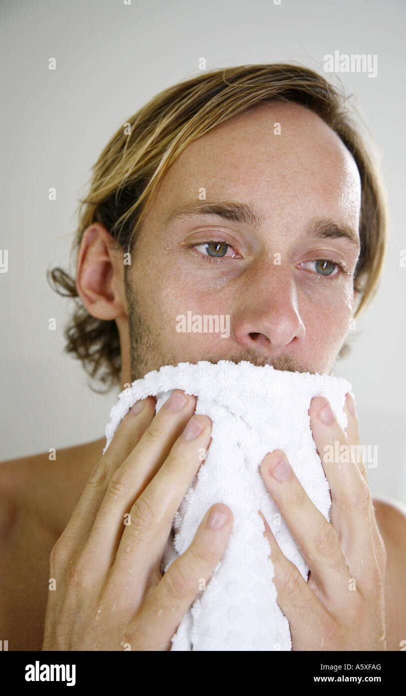 Young man drying his face with a towel close up portrait Stock Photo ...