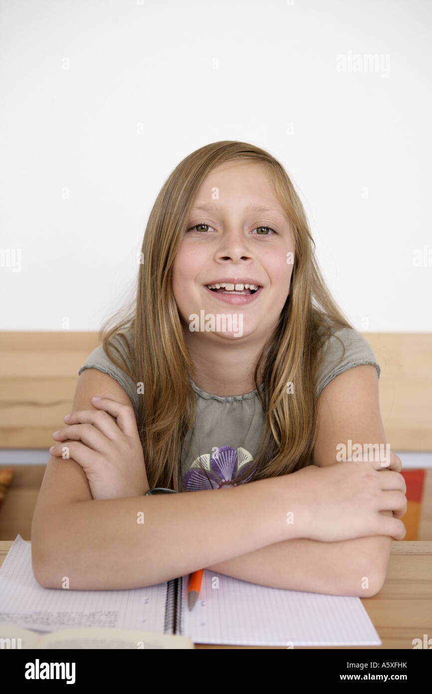 Girl sitting at desk smiling close up portrait Stock Photo - Alamy
