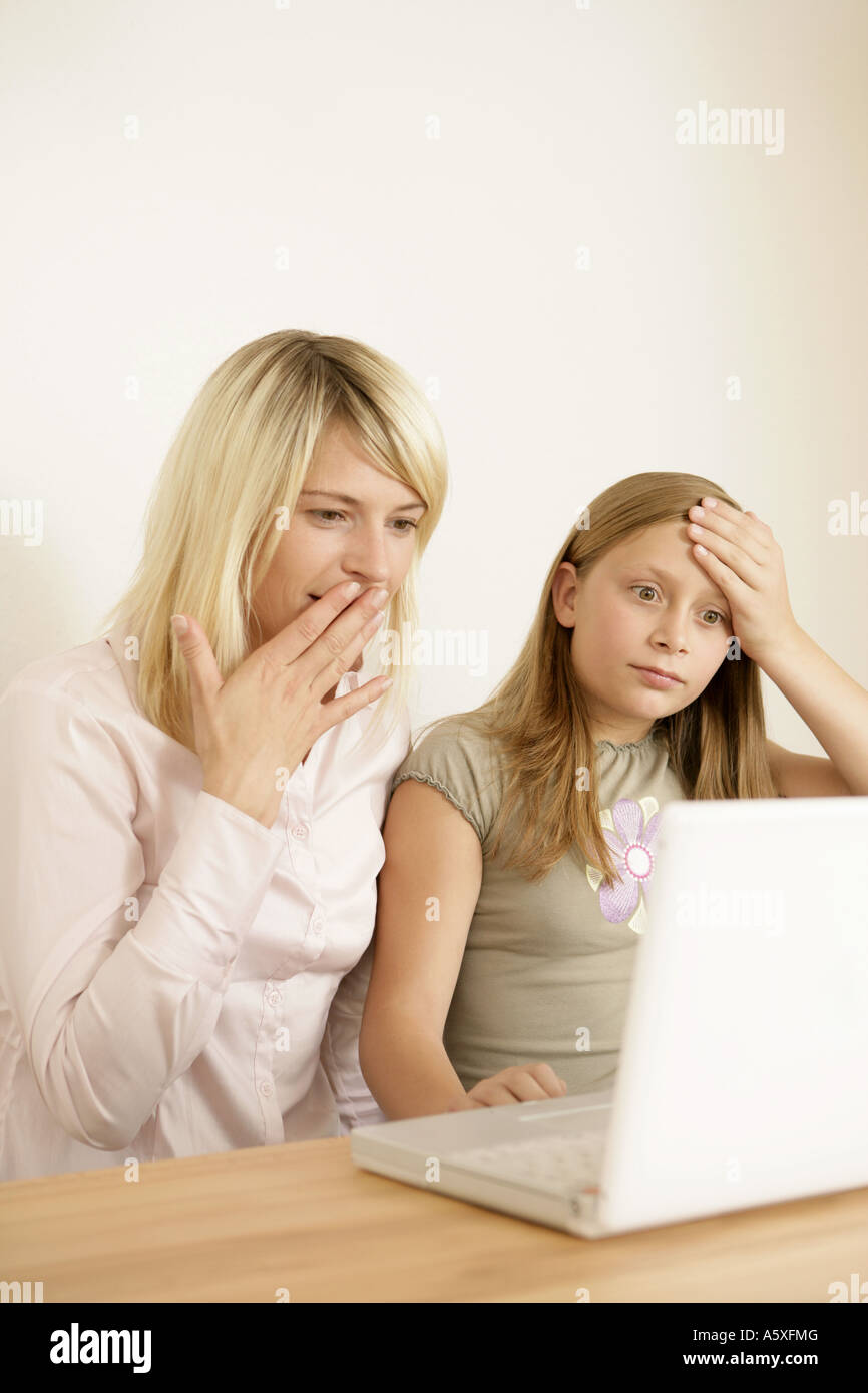 Mother and daughter using laptop scared looking close up Stock Photo ...