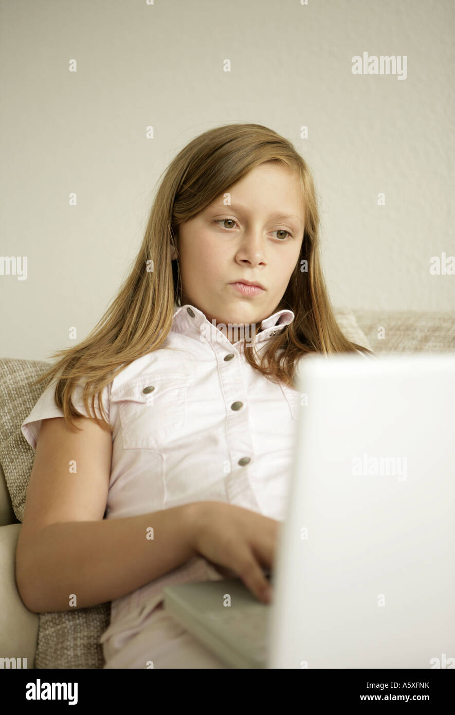 Girl sitting on sofa and using laptop angry close up Stock Photo - Alamy