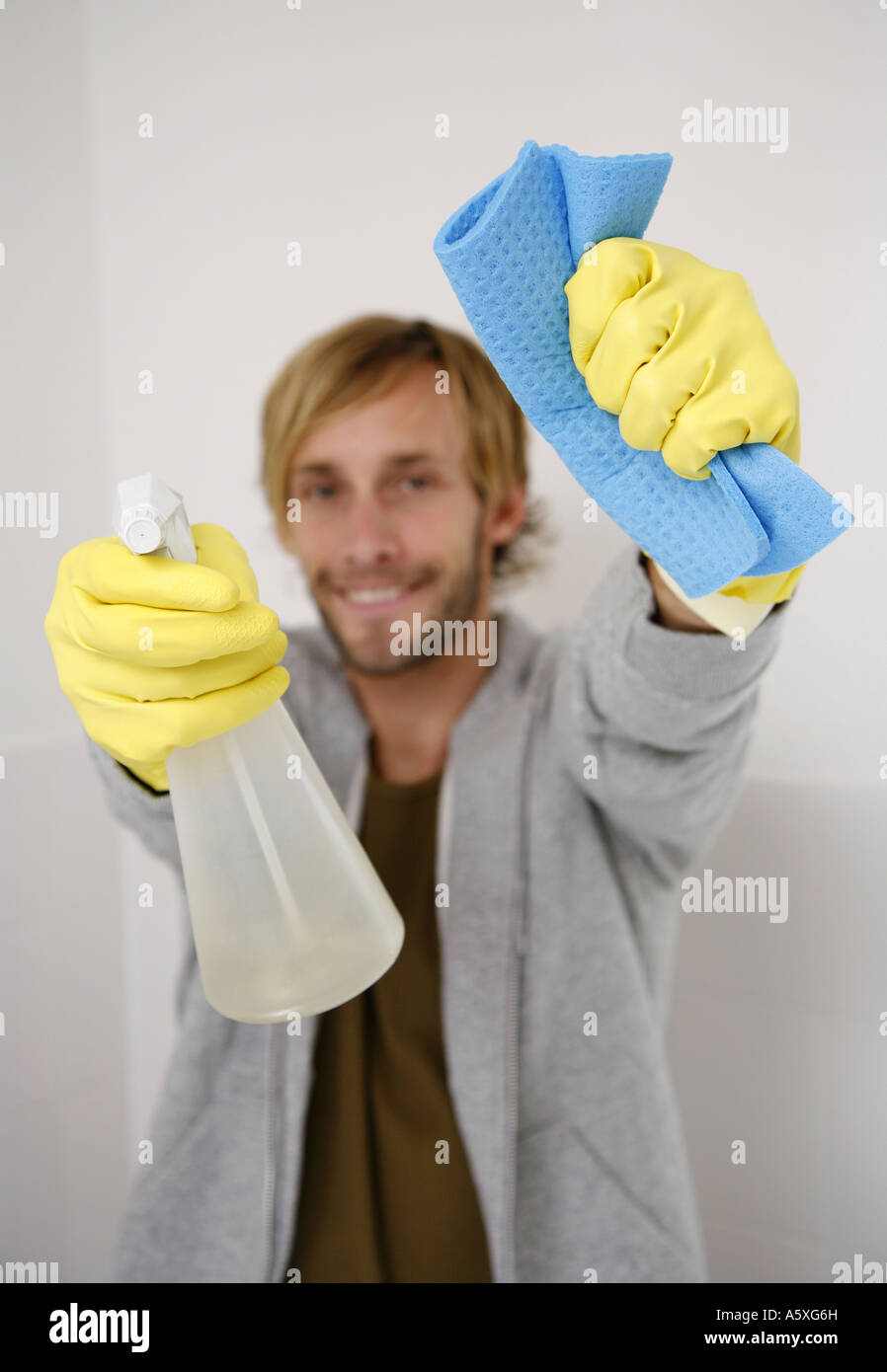 Young man holding spray bottle and duster focus on cleaning utensils ...