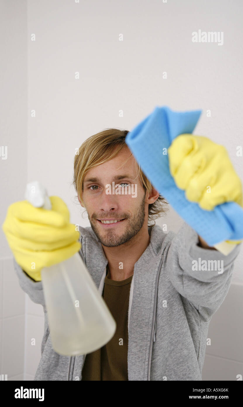 Young man holding spray bottle and duster focus on man Stock Photo - Alamy