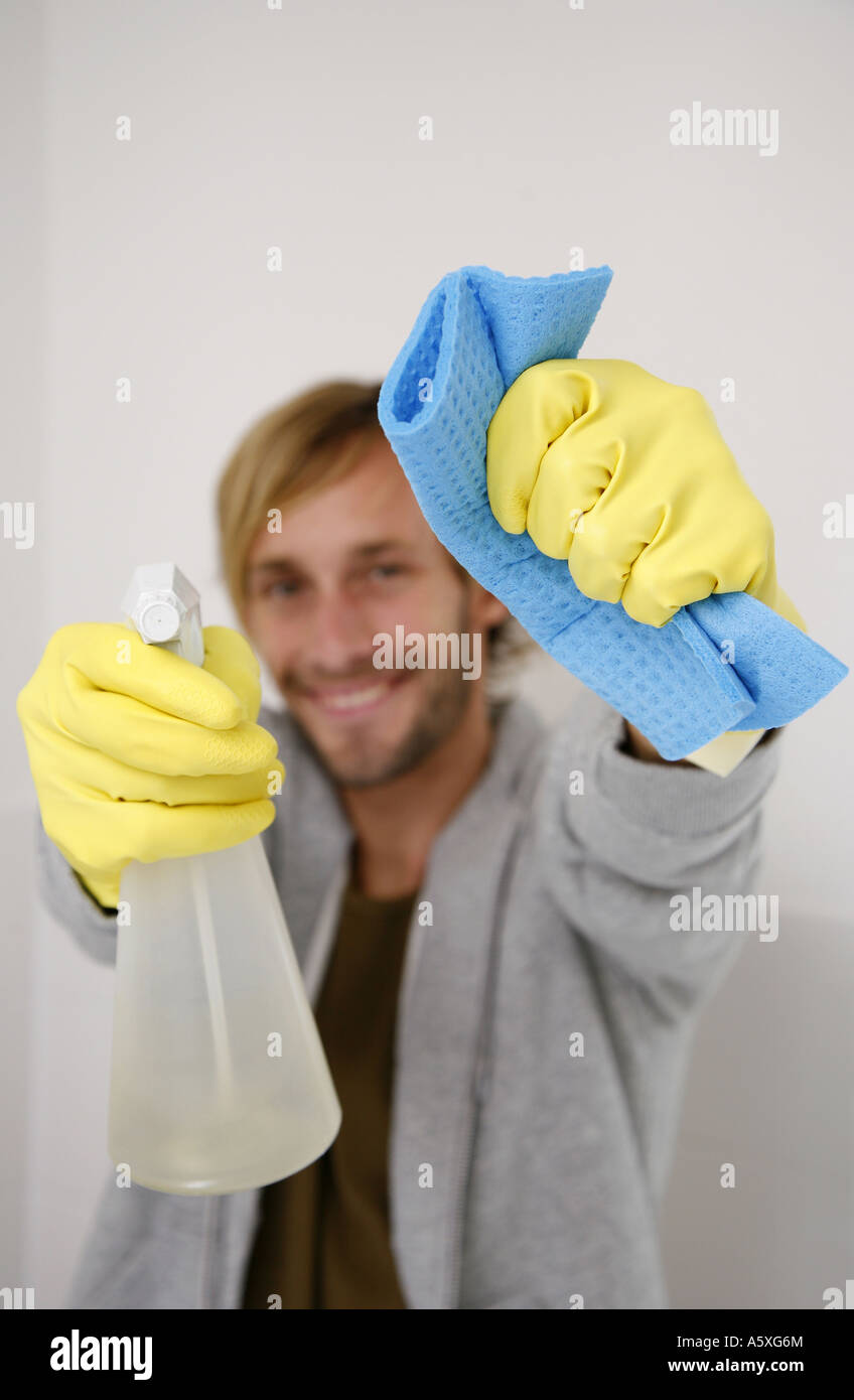 Young man holding spray bottle and duster focus on cleaning utensils ...