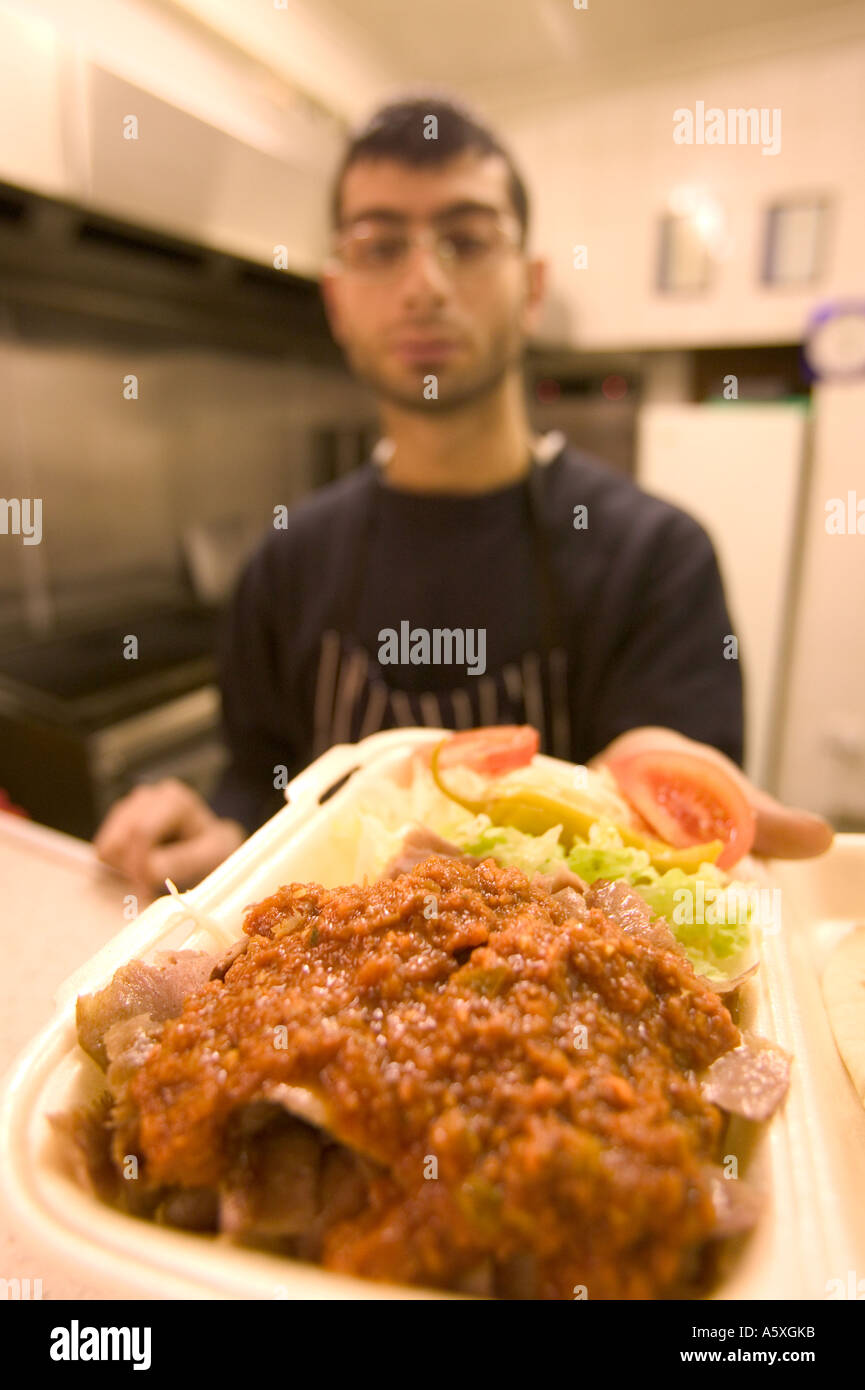 a Turkish man hands over a kebab in a kebab shop, in Lancaster city ...