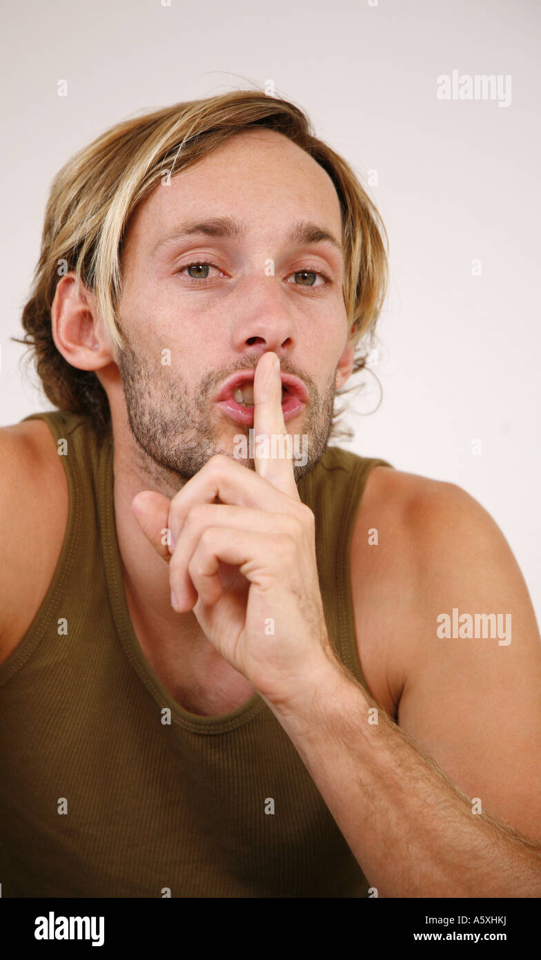 Young man with finger on lips portrait close up Stock Photo - Alamy