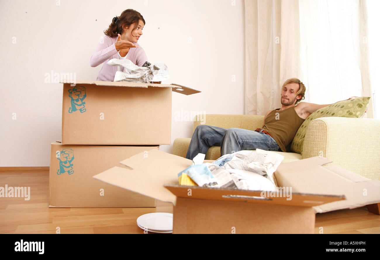 Young couple in living room with stack of boxes Stock Photo - Alamy