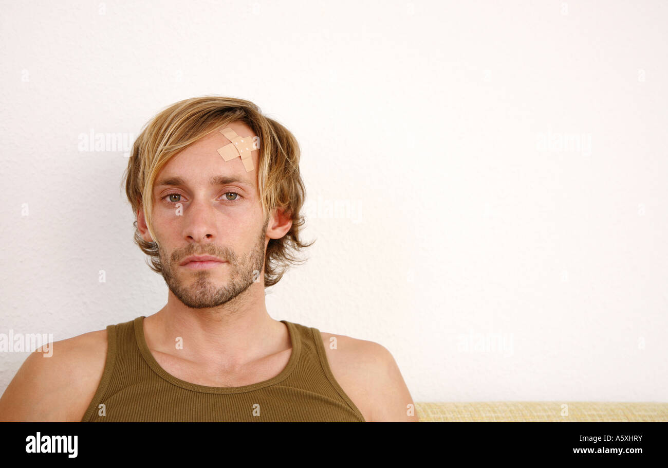 Young man with plaster on forehead portrait close up Stock Photo - Alamy