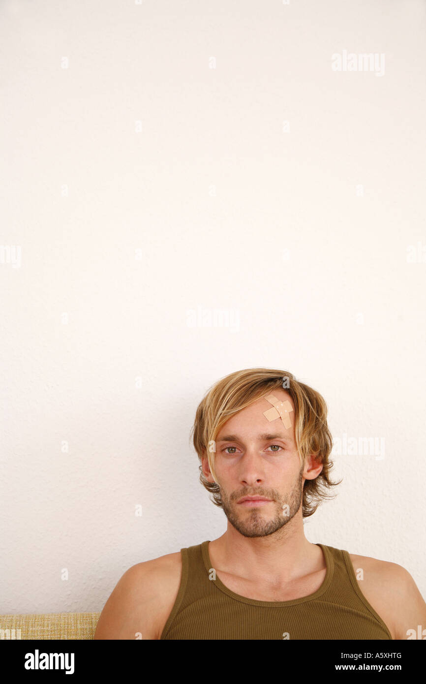Young man with plaster on forehead portrait close up Stock Photo - Alamy
