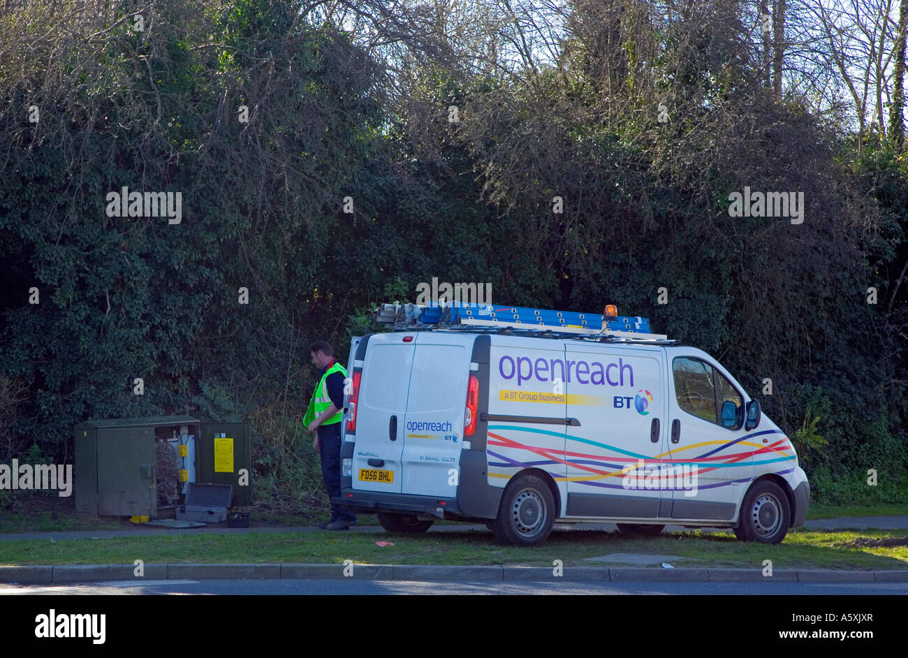 BT Openreach engineer by his service van at a street telephone cabinet ...