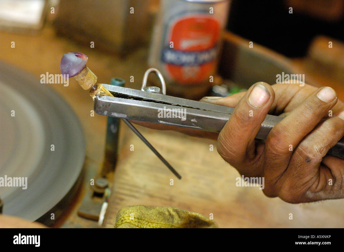 A worker polishing rough gemstone in a shop in Banlung, a town in the ...