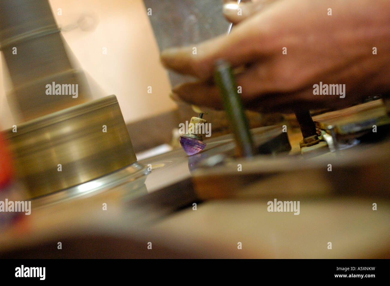 A worker polishing rough gemstone in a shop in Banlung, a town in the ...