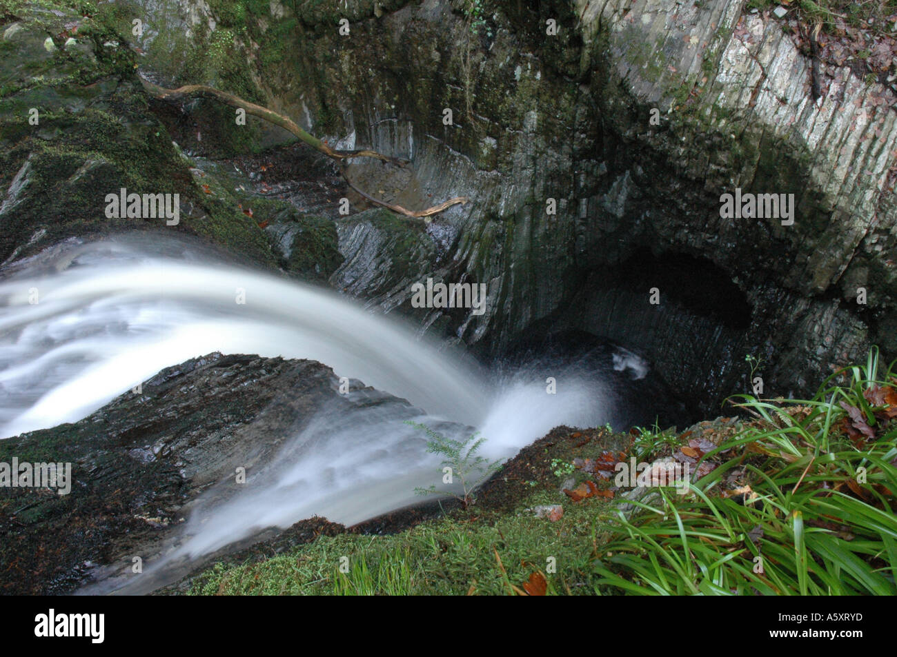 view looking down a waterfall going into cave Stock Photo - Alamy