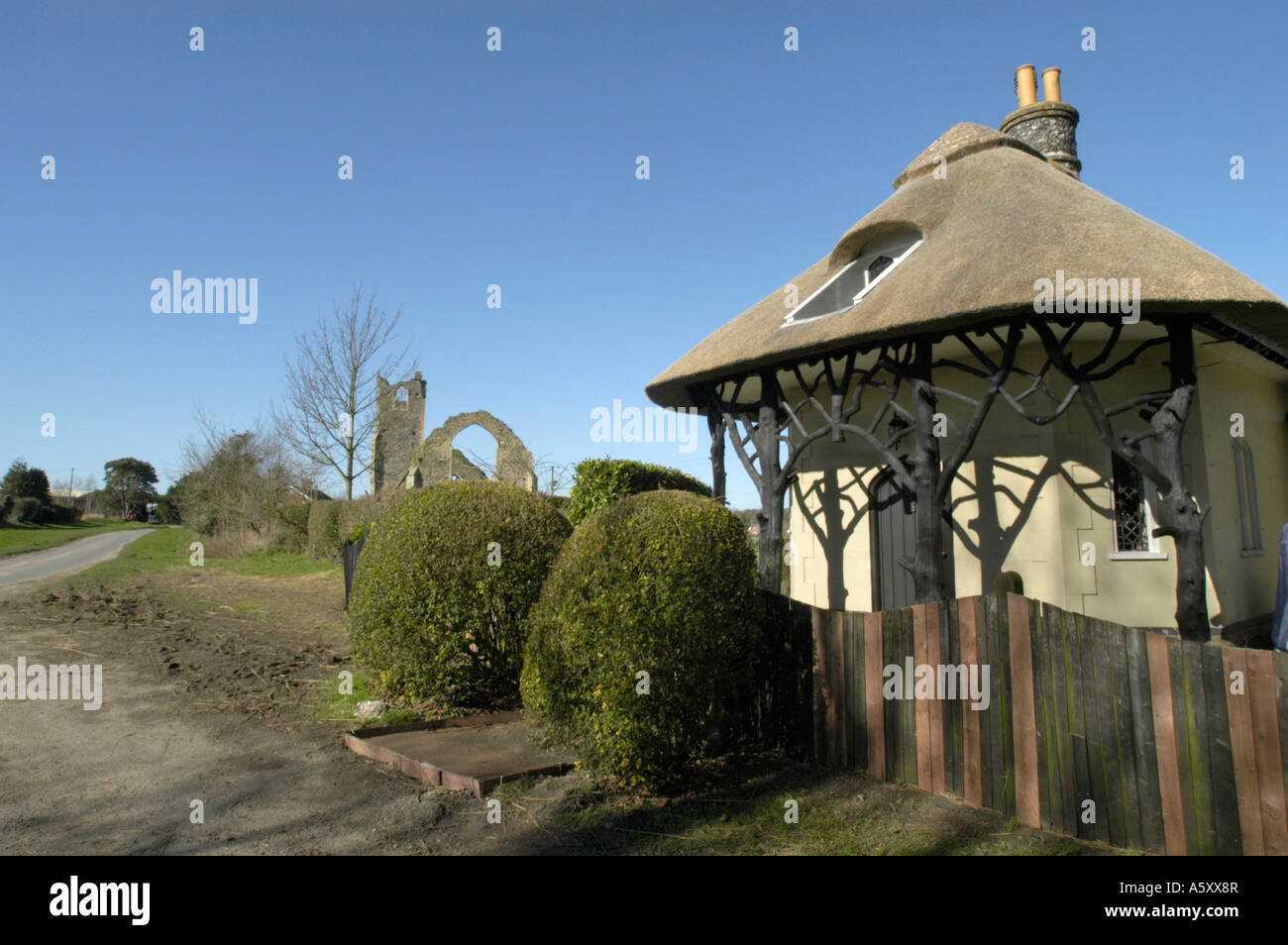Thatched cottage beside the ruins of St Andrews church Roudham Norfolk ...