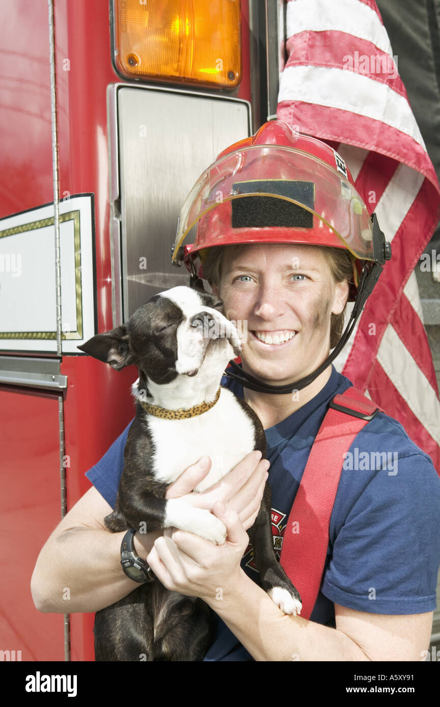 Female firefighter holding Boston Terrier Stock Photo - Alamy