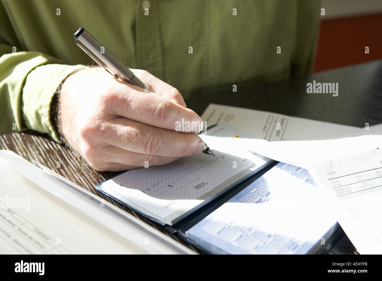 Closeup of man writing out a check Stock Photo - Alamy