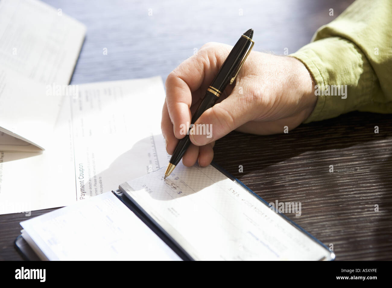 Closeup of man writing out a check Stock Photo - Alamy