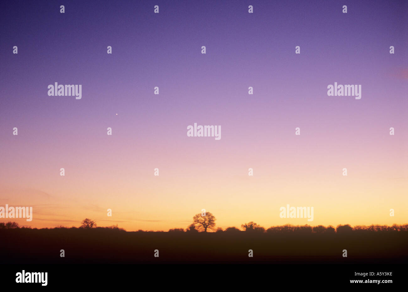Cloudless sunset sky with a single star and colours ranging from orange ...