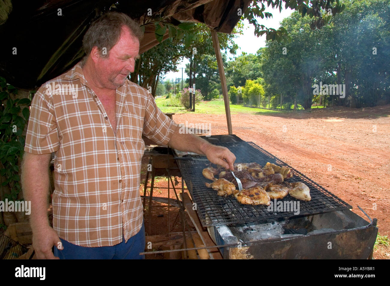 A man grilling chicken in Argentina Stock Photo - Alamy