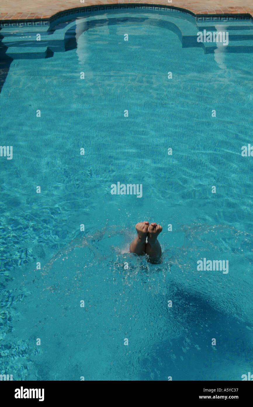 Woman diving into pool at a villa Stock Photo - Alamy