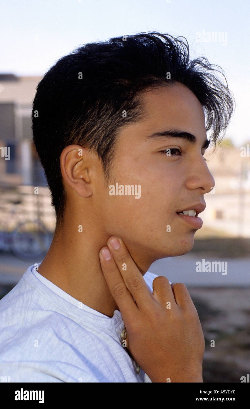 A teenage boy checking his pulse with two fingers on his neck Stock ...