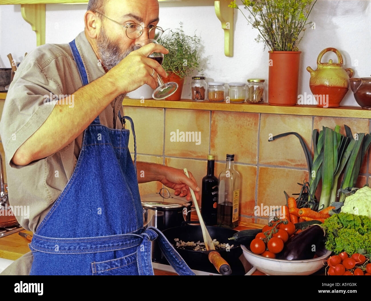 man cooking in the kitchen drinking a glass of wine Stock Photo - Alamy